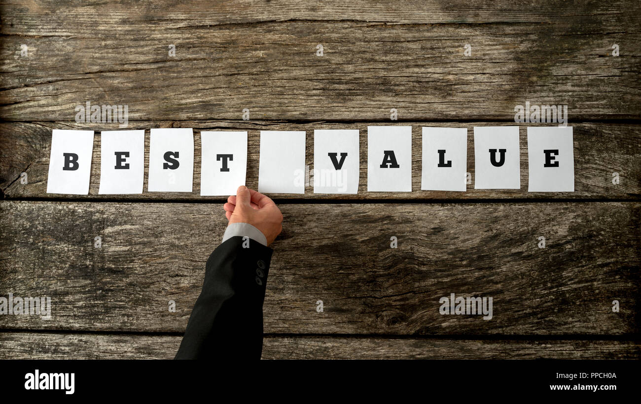 Salesman assembling a Best value sign with white cards over a textured ...