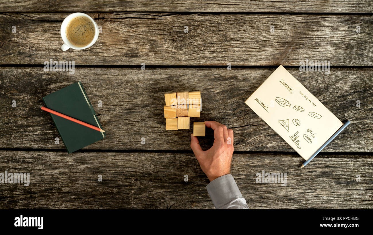 Research and brainstorming - top view of male hand placing wooden cubes ...