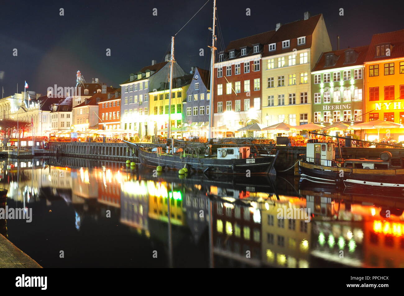 Nyhavn Harbour in Copenhagen, Denmark by night with water reflections ...
