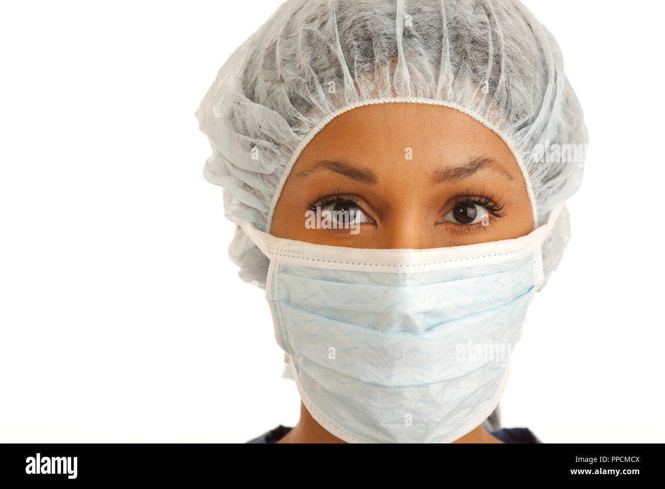 Close up of female surgeon wearing mask and hair net on white backdrop ...