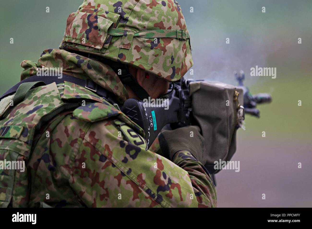 A member of the Japan Ground Defense Force takes aim for training ...