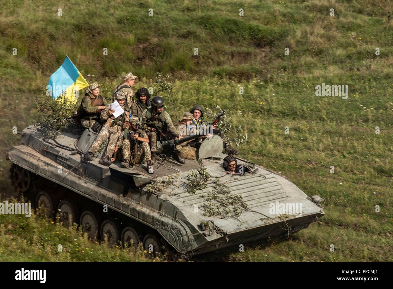 Ukrainian Soldiers ride on top of a BMP with the Ukrainian flag during ...