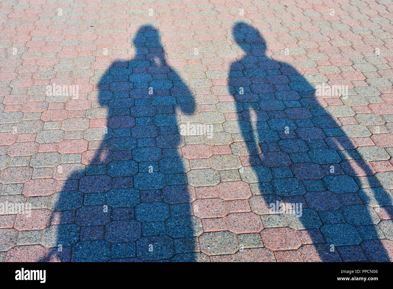 textureSilhouettes of two people on a paved pathway Stock Photo - Alamy