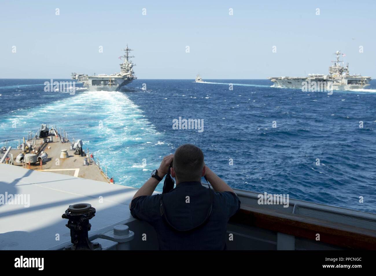 ATLANTIC OCEAN (Aug. 30, 2018) Ensign James Segrave uses binoculars ...