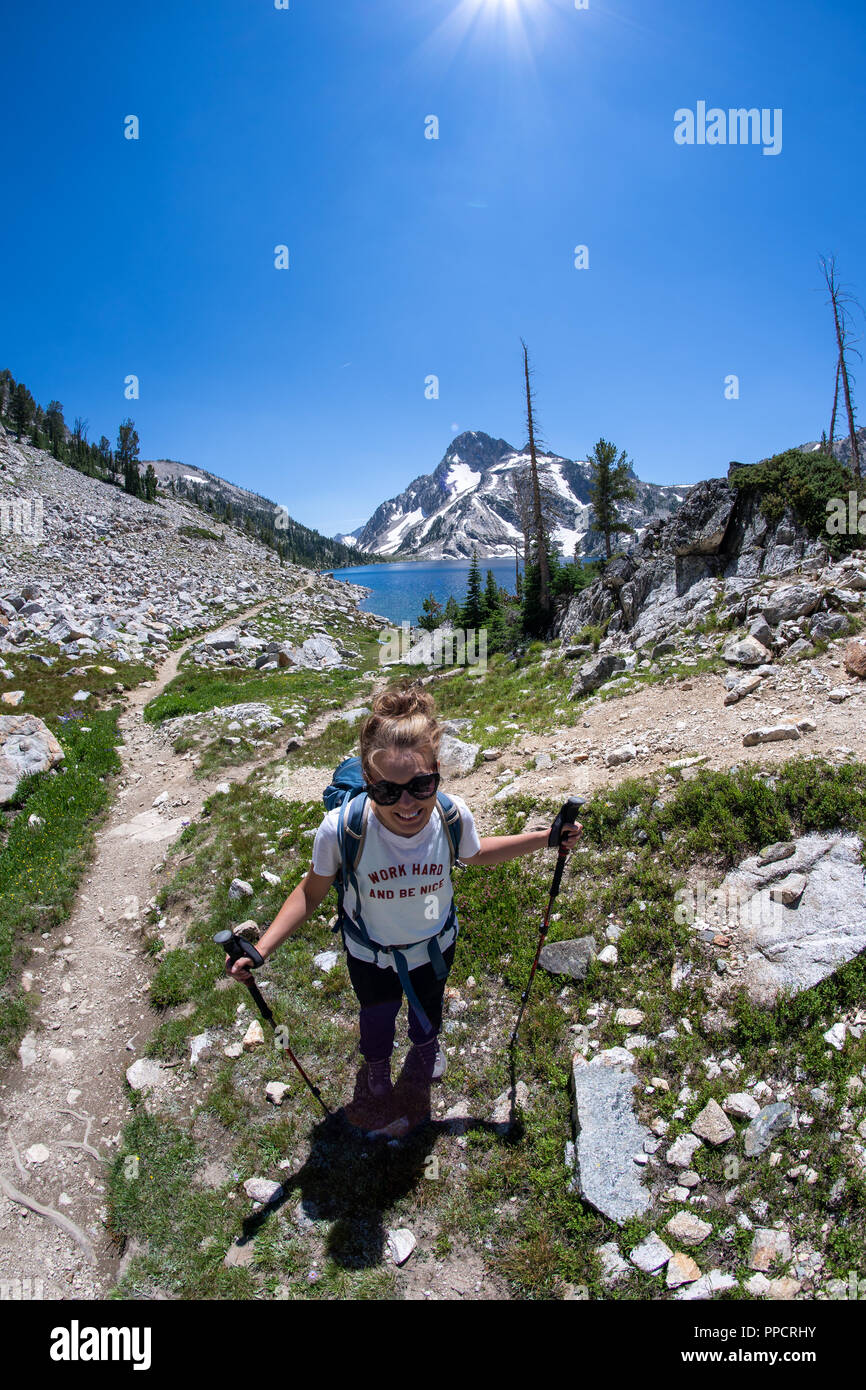 Woman hiker stands on the trail of Sawtooth Lake in Idaho’s Sawtooth ...