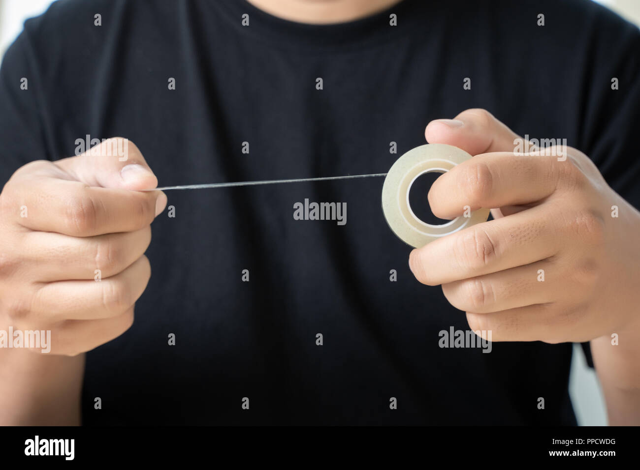 Close up of a man packaging tape roll adhesive tap Stock Photo - Alamy