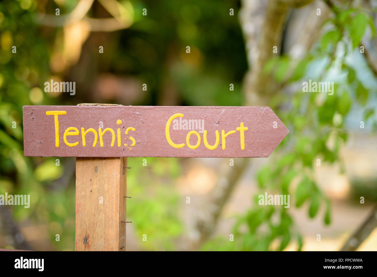 Wooden Signpost Pointing To The Tennis Court Stock Photo - Alamy