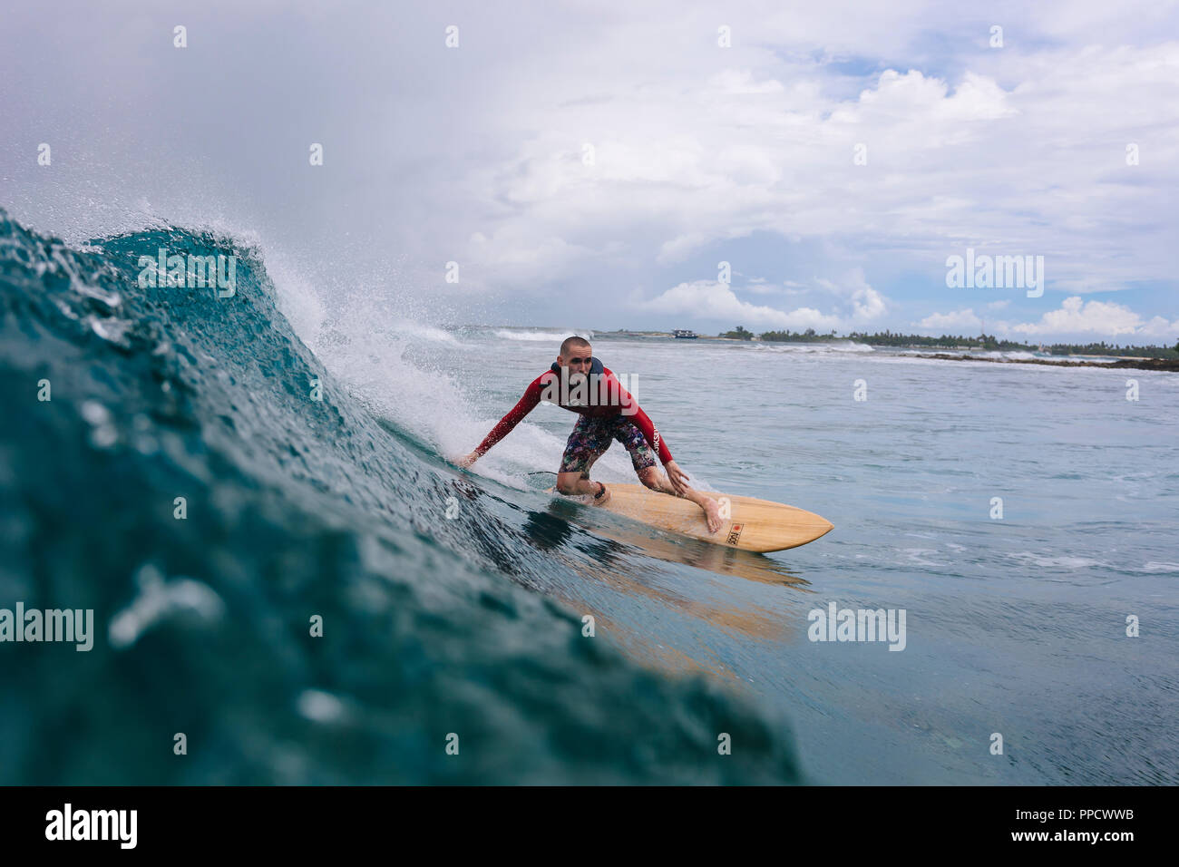 Large clouds over male surfer riding wave, Male, Maldives Stock Photo ...