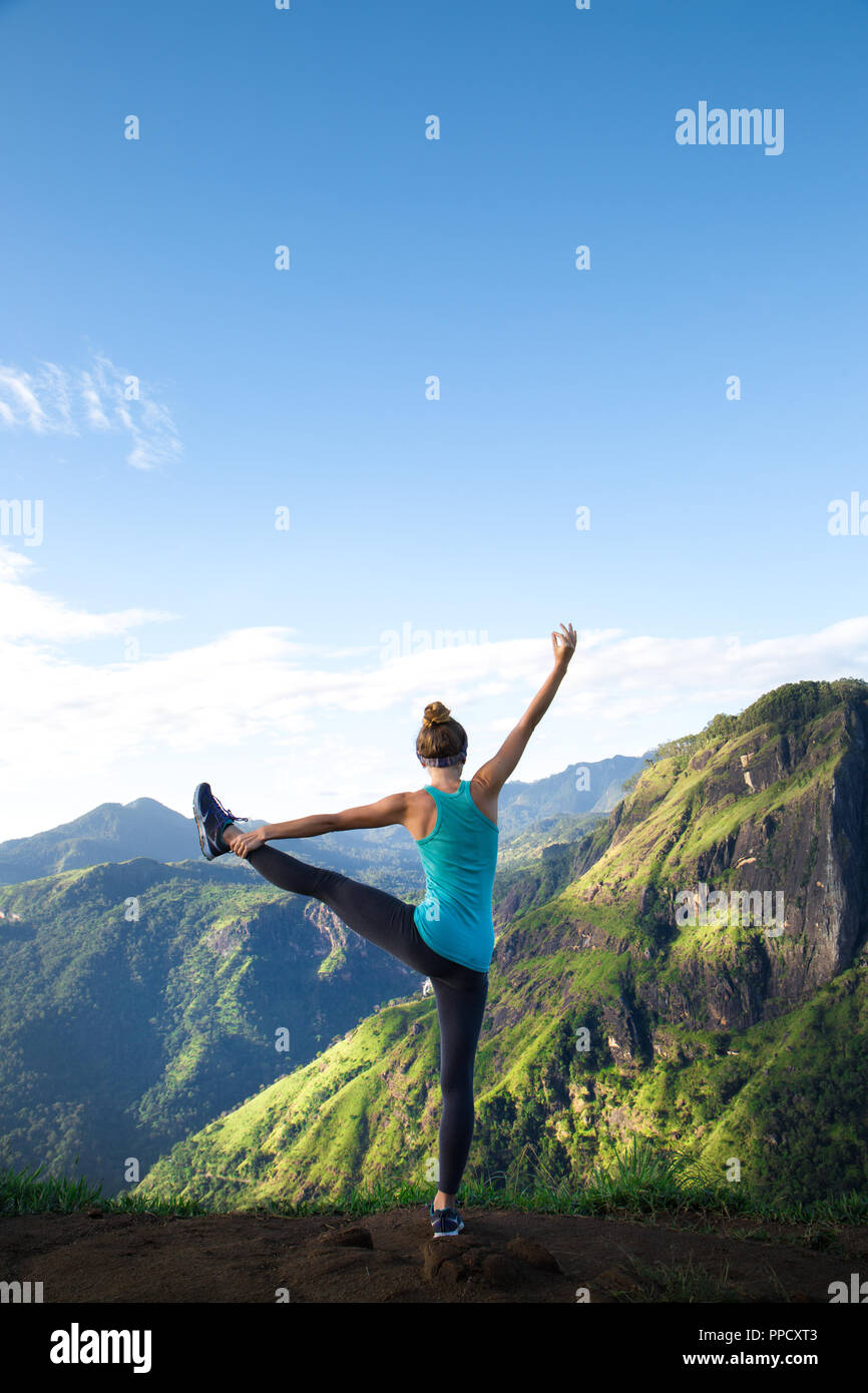 Girl doing a stand on balance at the top of the mountain Stock Photo ...