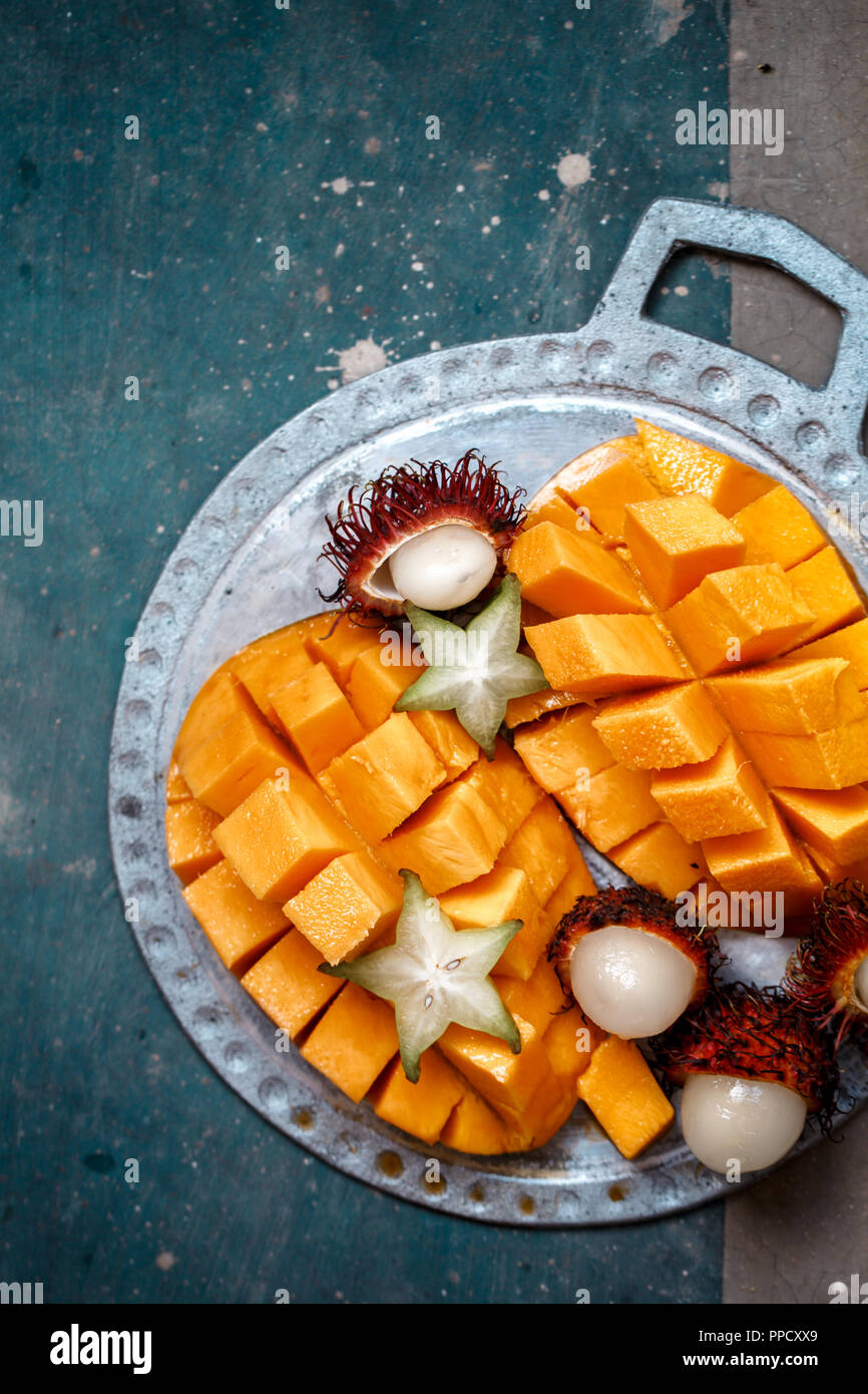 Juicy, ripe mango, rambutan and Cannon on a metal plate Stock Photo - Alamy