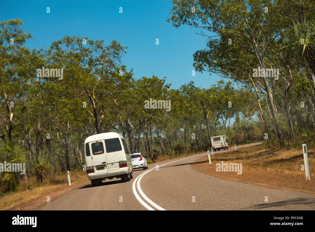White camper bus driving in the forest of the litchfield national park ...