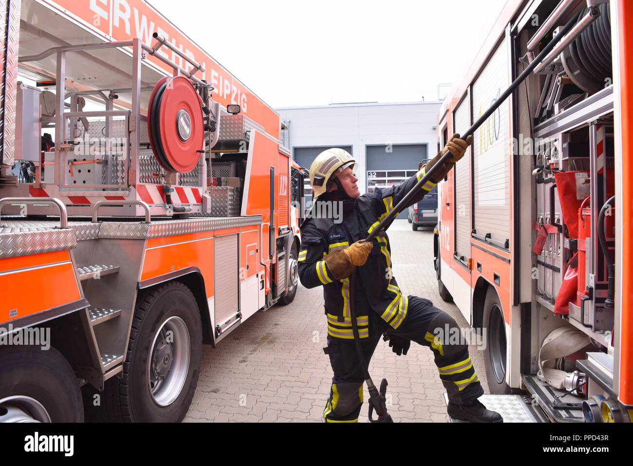 portrait of a firefighter at the emergency vehicle in the fire station ...
