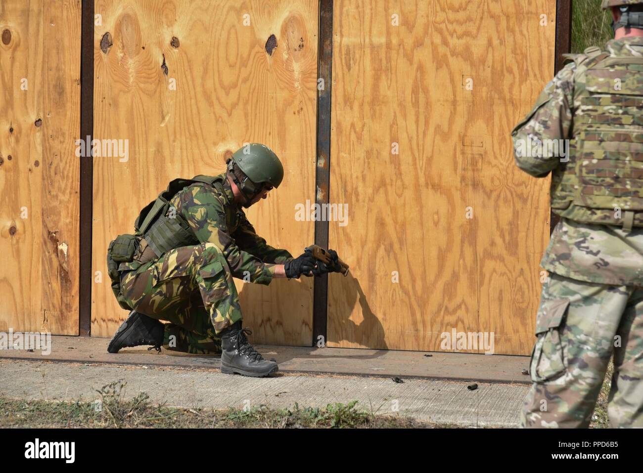 A Dutch Soldier uses an M500 shotgun to breach a door during the Urban ...