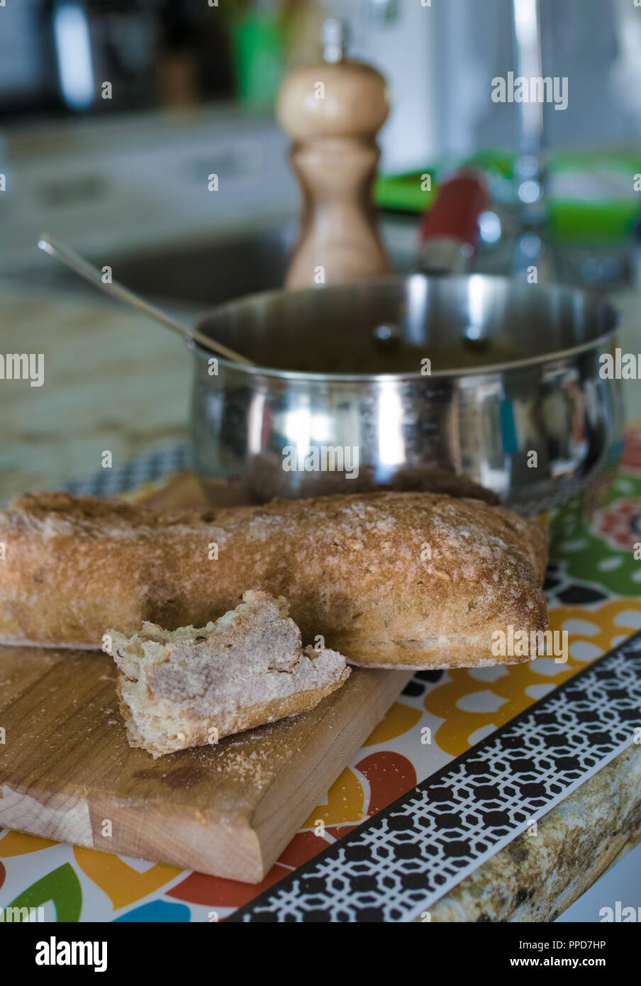 A cauldron, rustic bread on the breadboard, a saltcellar, all in the ...