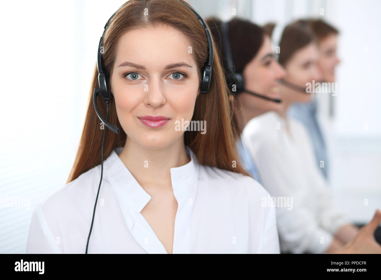 Call center. Beautiful cheerful smiling operator consulting clients with headset. Business ...