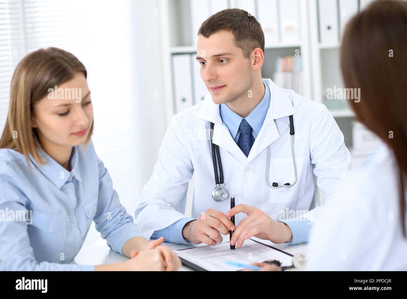 Patient listening doctors sitting table hi-res stock photography and ...