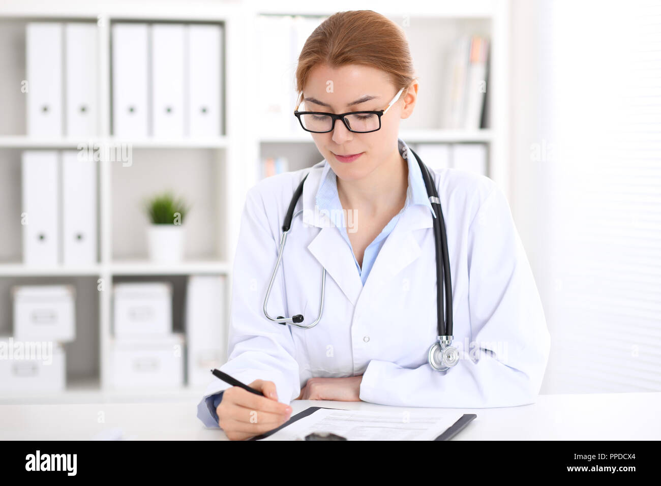 Young brunette female doctor at work in hospital. Physician ready to ...