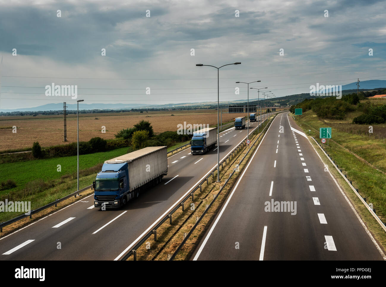Caravan or convoy of lorry trucks in line on a country highway Stock ...
