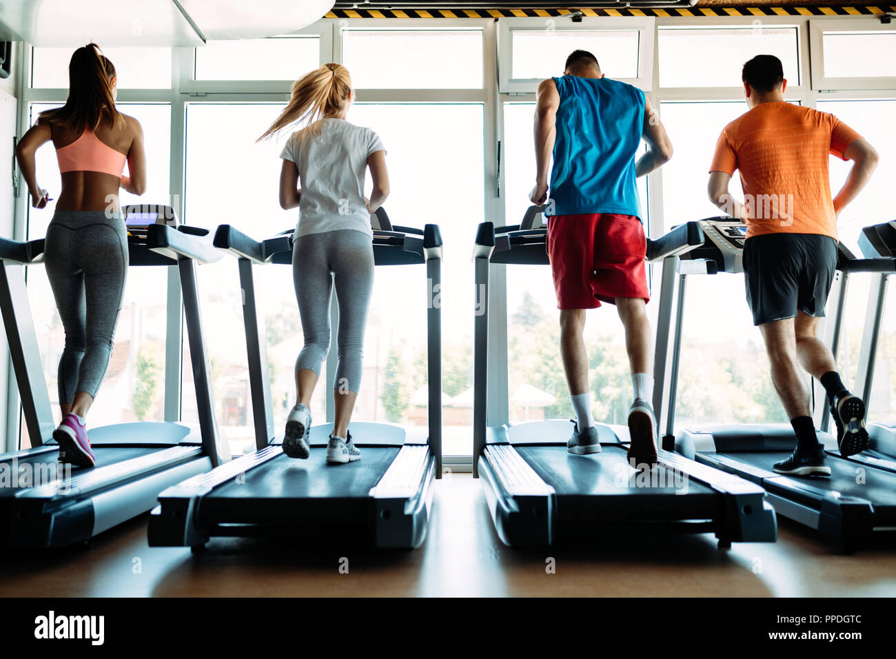 Happy people on treadmills in the gym Stock Photo - Alamy