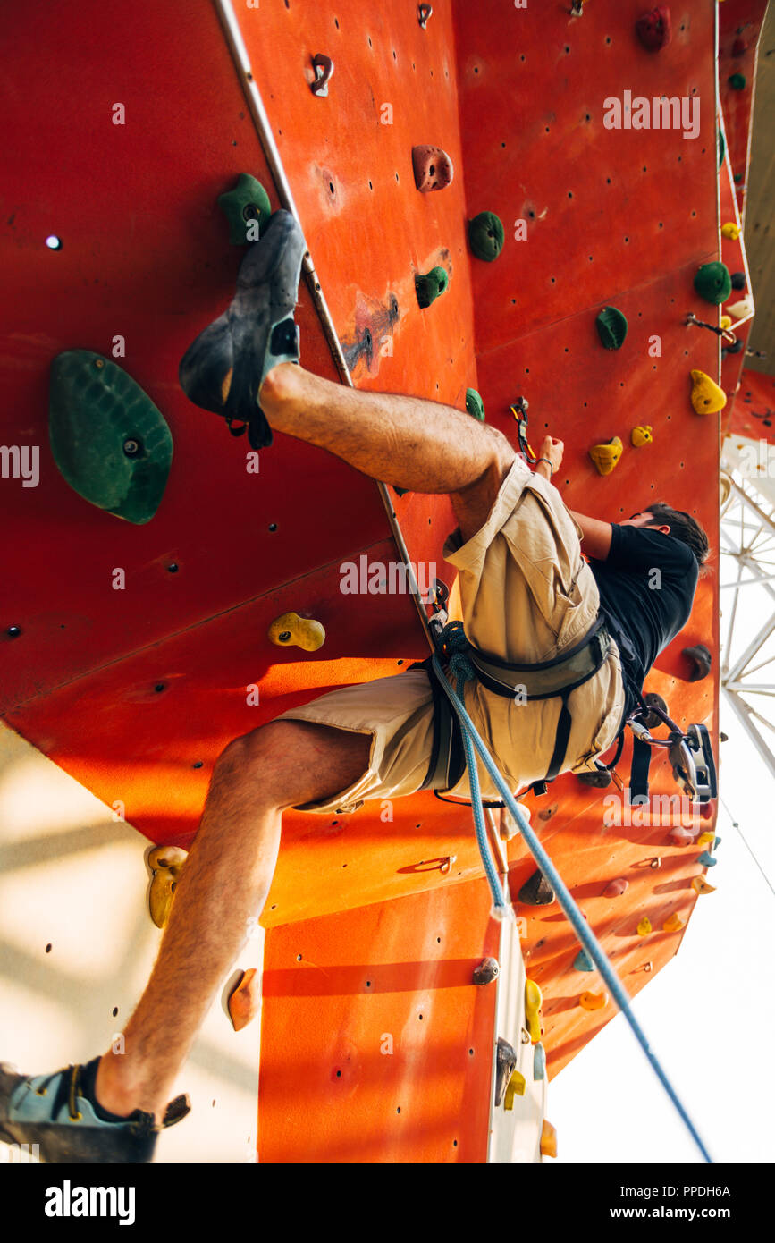 Man climber on artificial climbing wall in bouldering gym Stock Photo ...