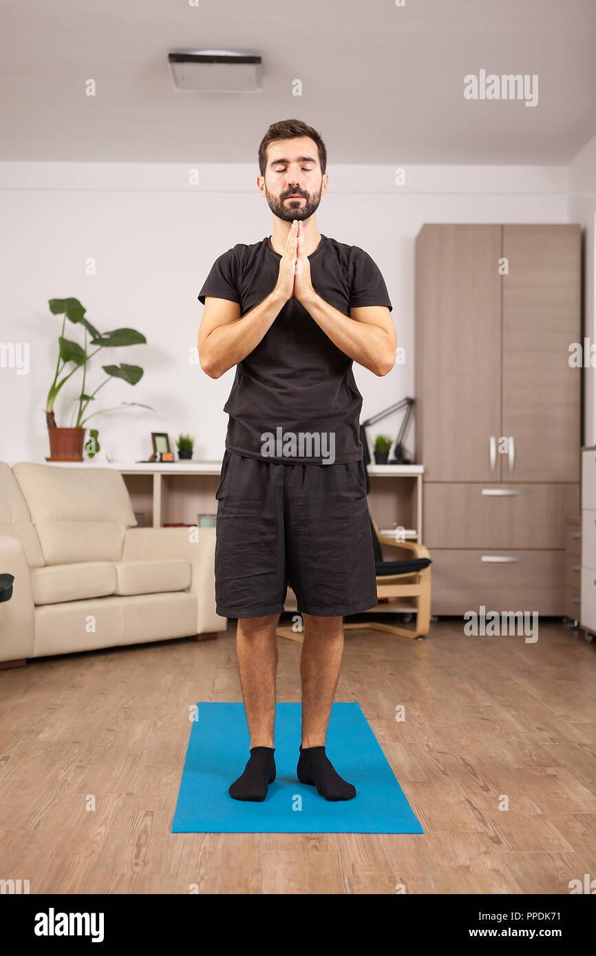 Fit man practicing yoga in the living room of his house Stock Photo - Alamy