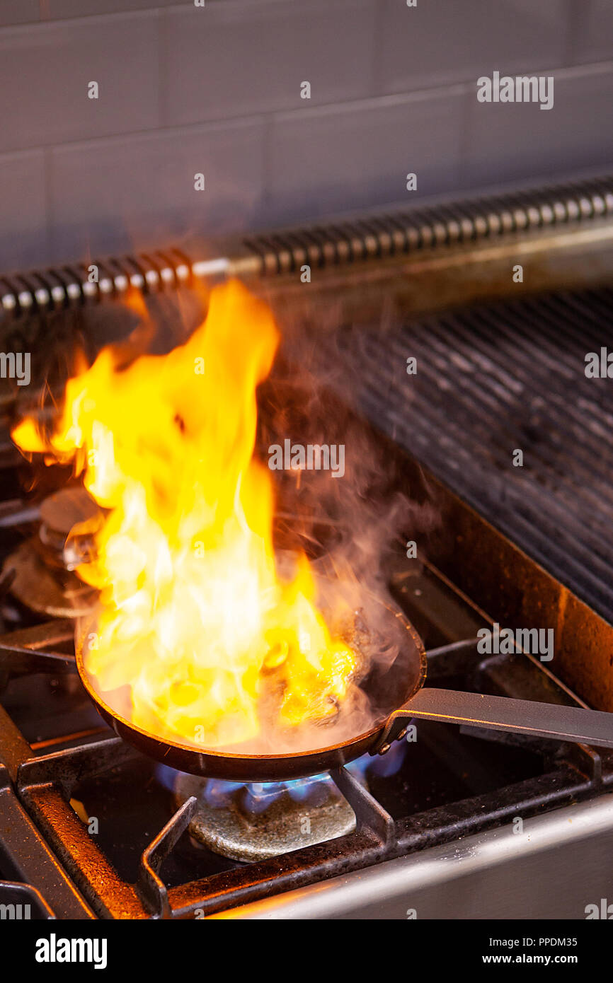 Chef making great flambe beef in restaurant kitchen Stock Photo - Alamy