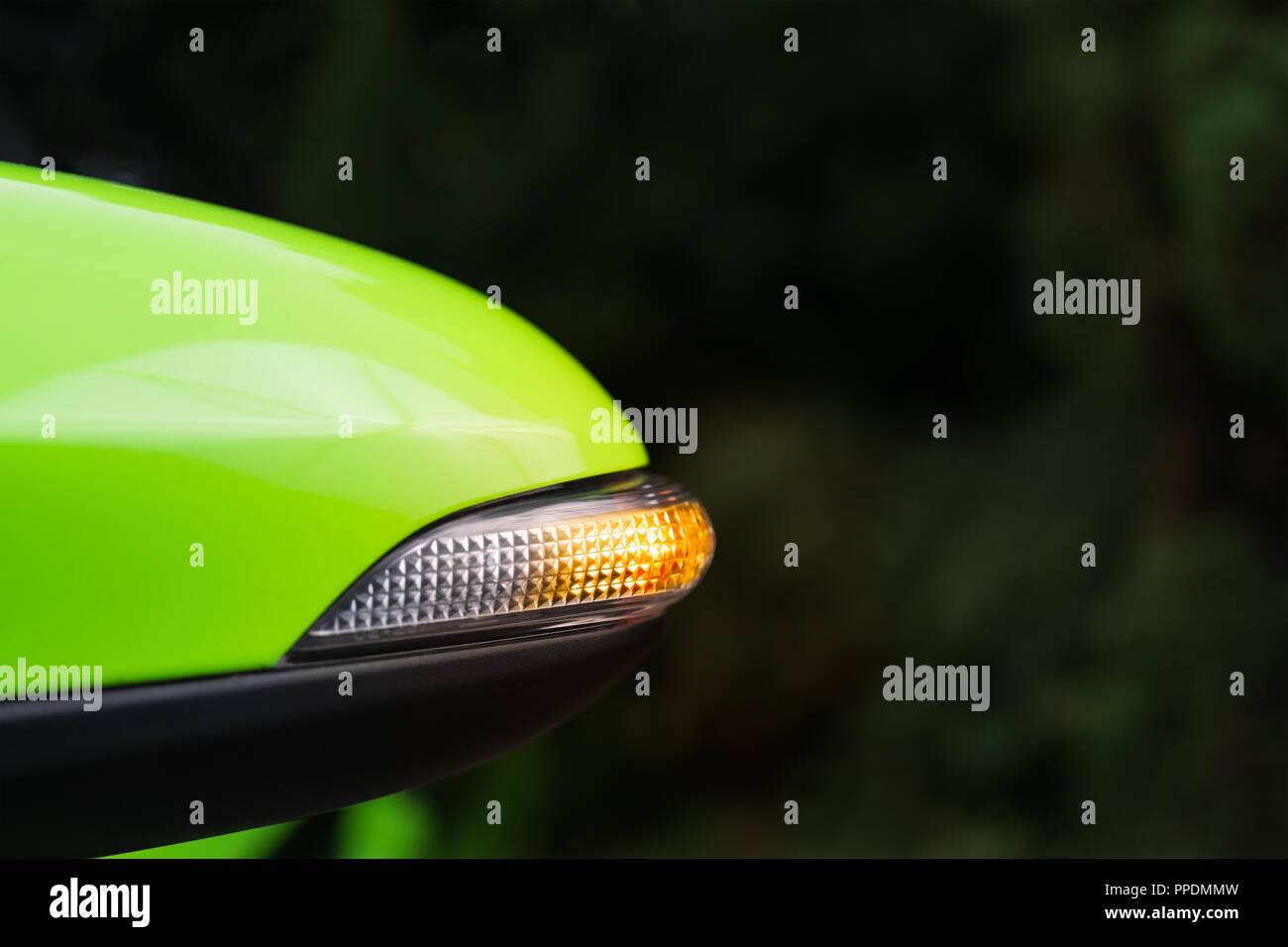 Turn signal or blinker lit in mirror of a modern green car Stock Photo ...