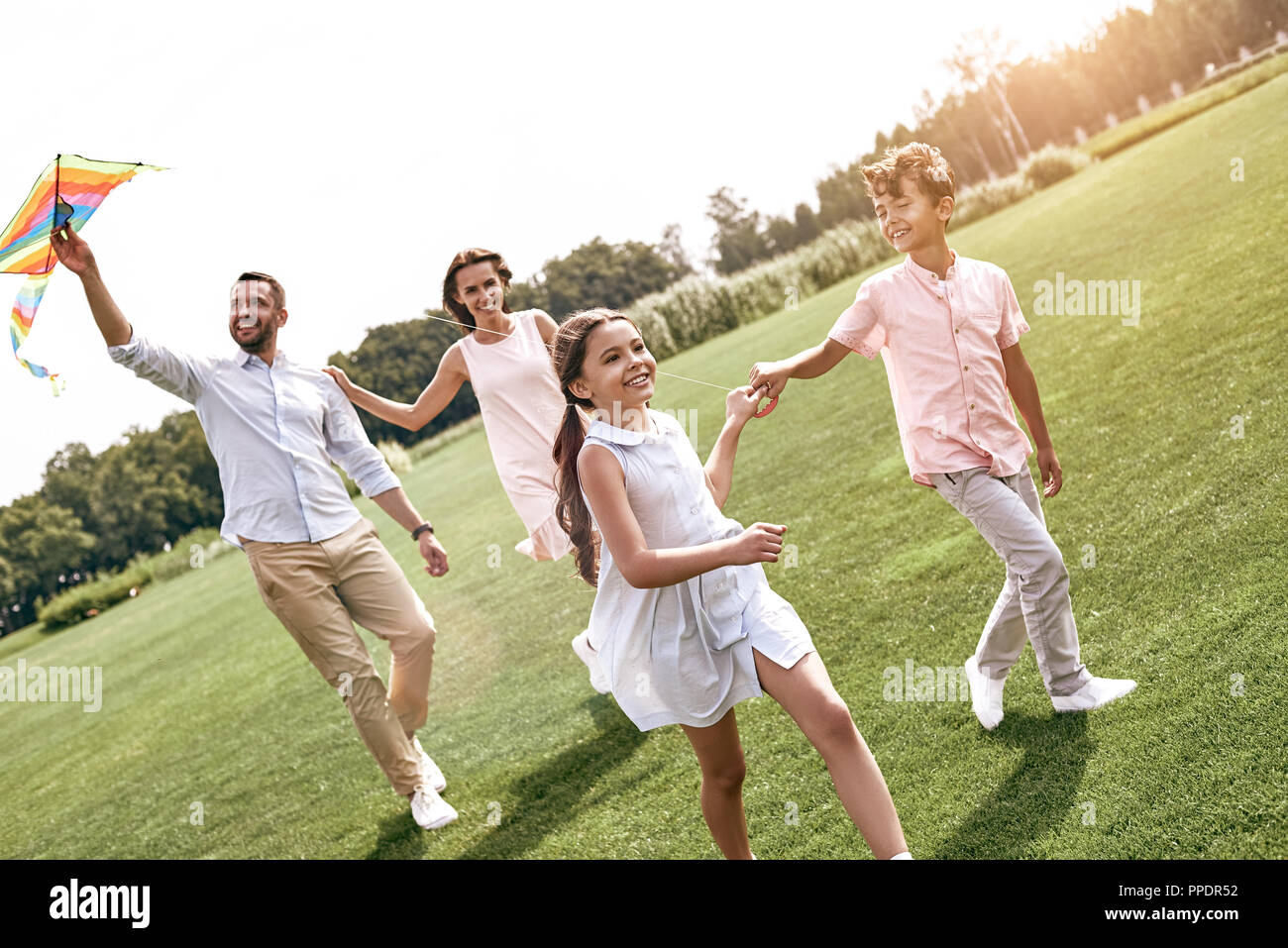Weekend activities. Family with a kite walking on field in natur Stock ...