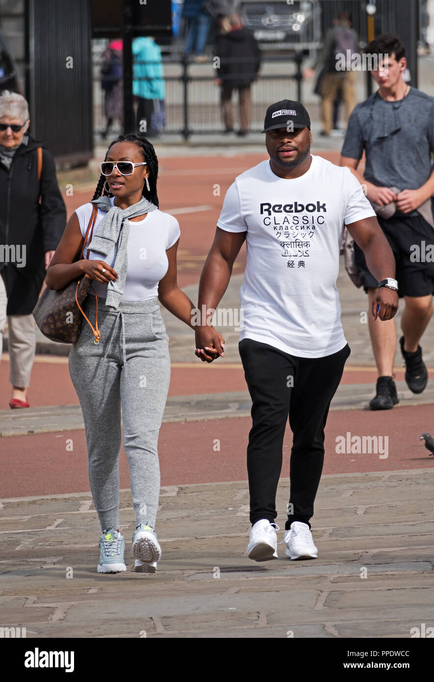 Young black couple holding hands whilst out walking Stock Photo - Alamy