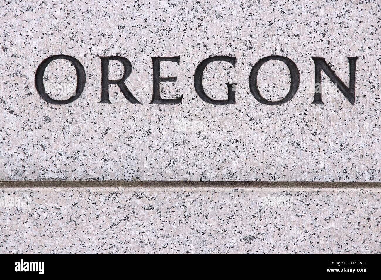 Oregon - US state name carved in grey granite stone Stock Photo - Alamy