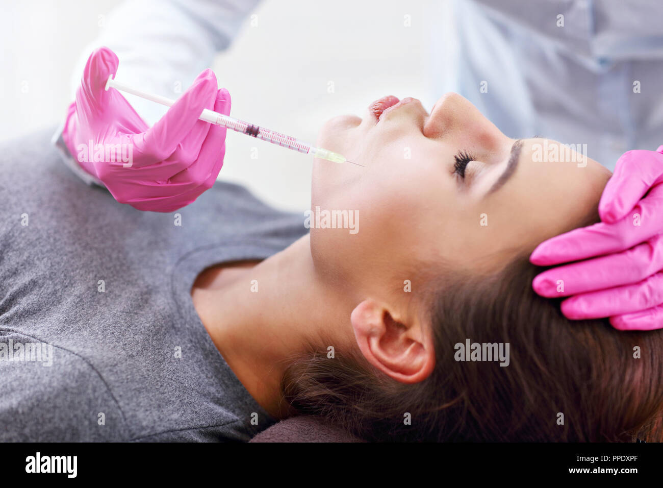 Attractive young woman gets cosmetic face injection Stock Photo - Alamy