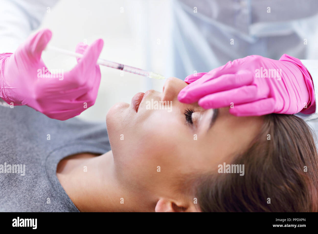 Attractive young woman gets cosmetic face injection Stock Photo - Alamy