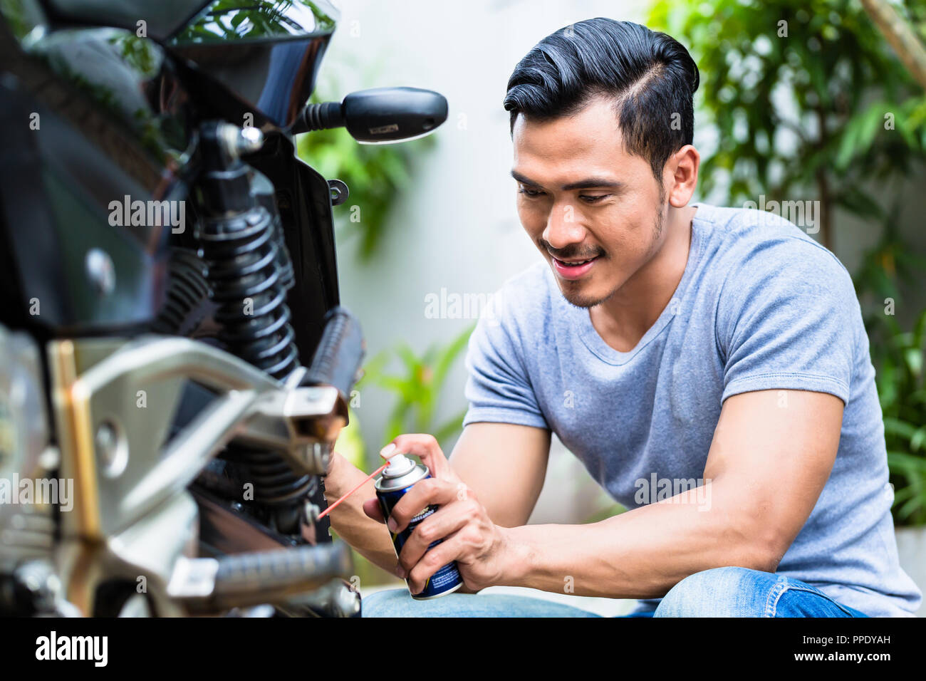 Man spraying grease in the motorbike Stock Photo - Alamy