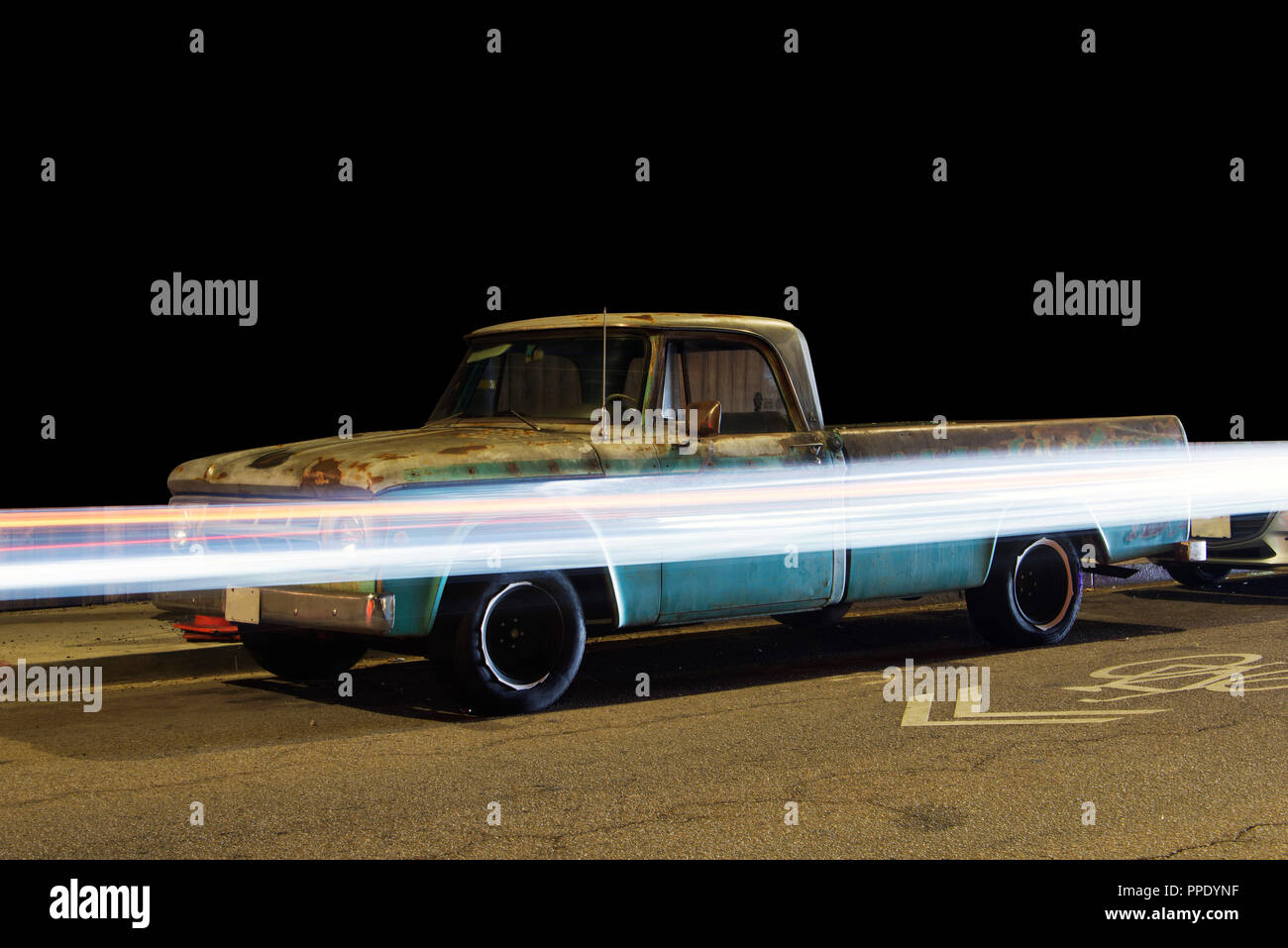 Side view of a vintage classic pick up truck car and light trails ...
