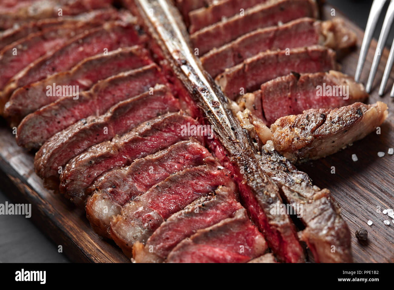 Sliced Steak T-bone lying on wooden board. Close-up. Top view. Still ...