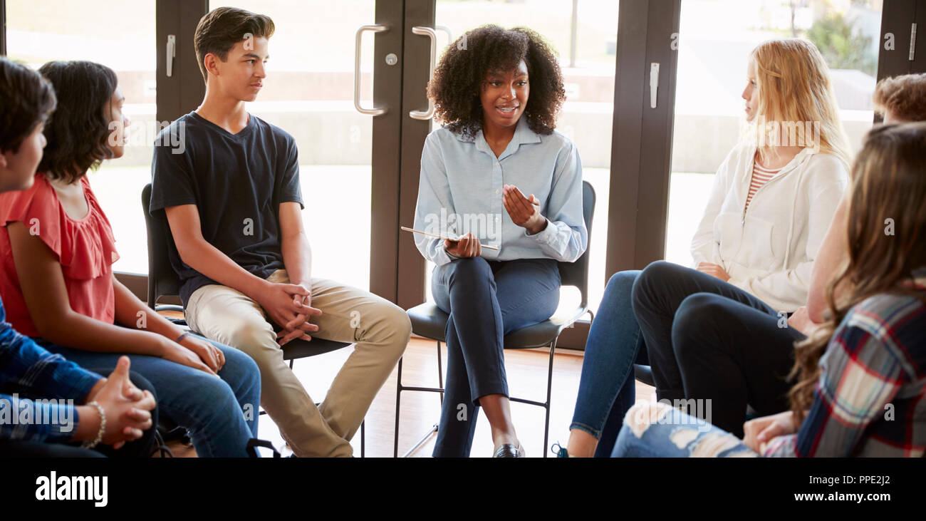 Female Tutor Leading Discussion Group Amongst High School Pupils Stock ...