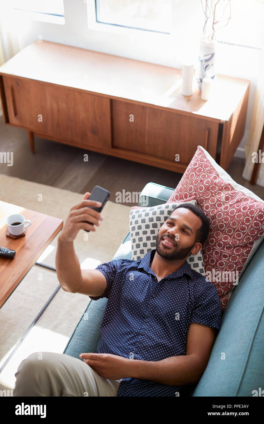 Overhead View Of Man Lying On Sofa At Home Posing For Selfie On Mobile ...