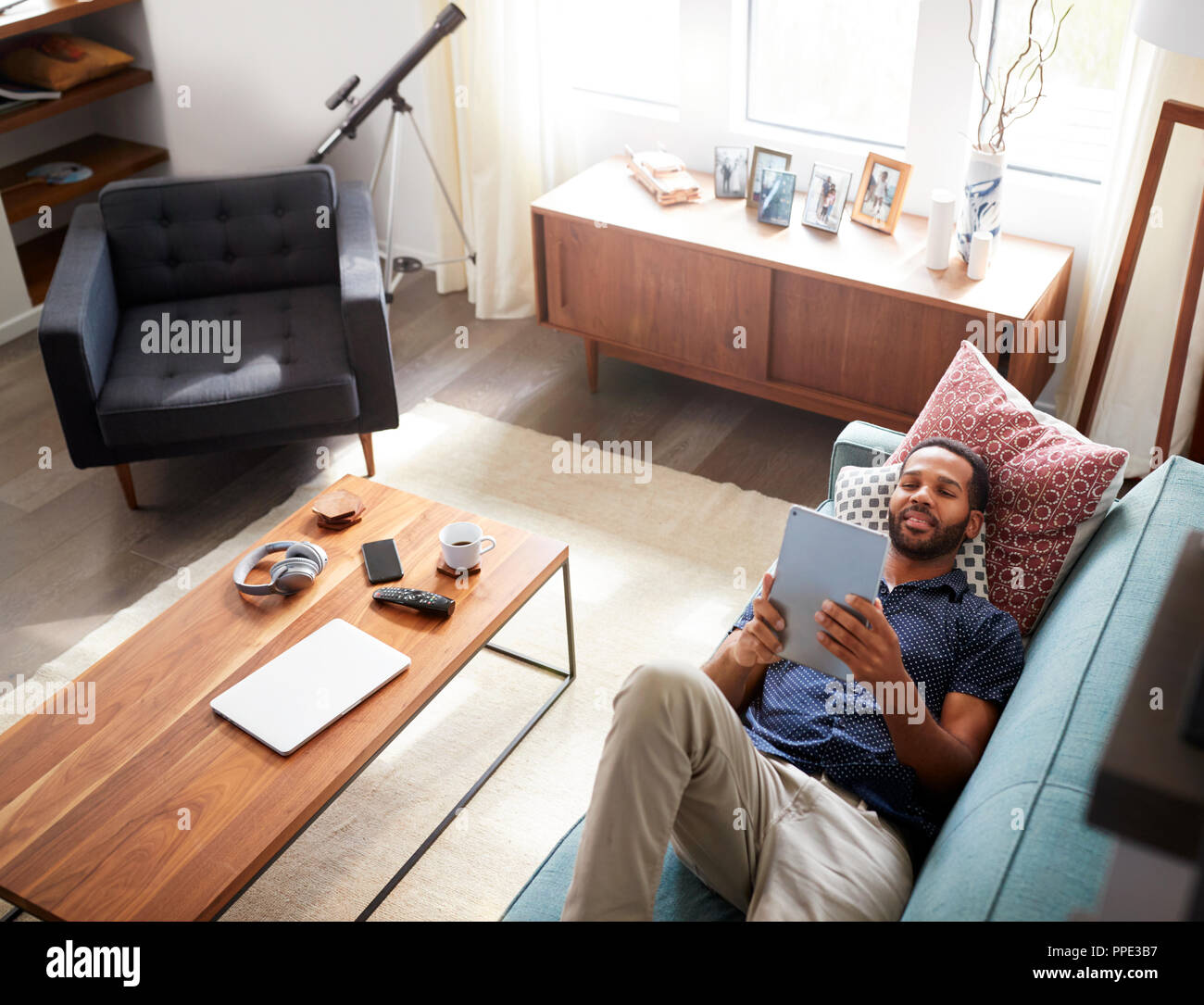 Overhead View Of Man Lying On Sofa At Home Watching Movie On Digital ...