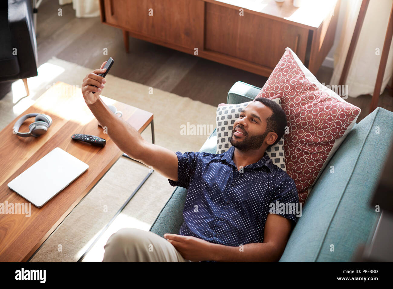 Overhead View Of Man Lying On Sofa At Home Posing For Selfie On Mobile ...