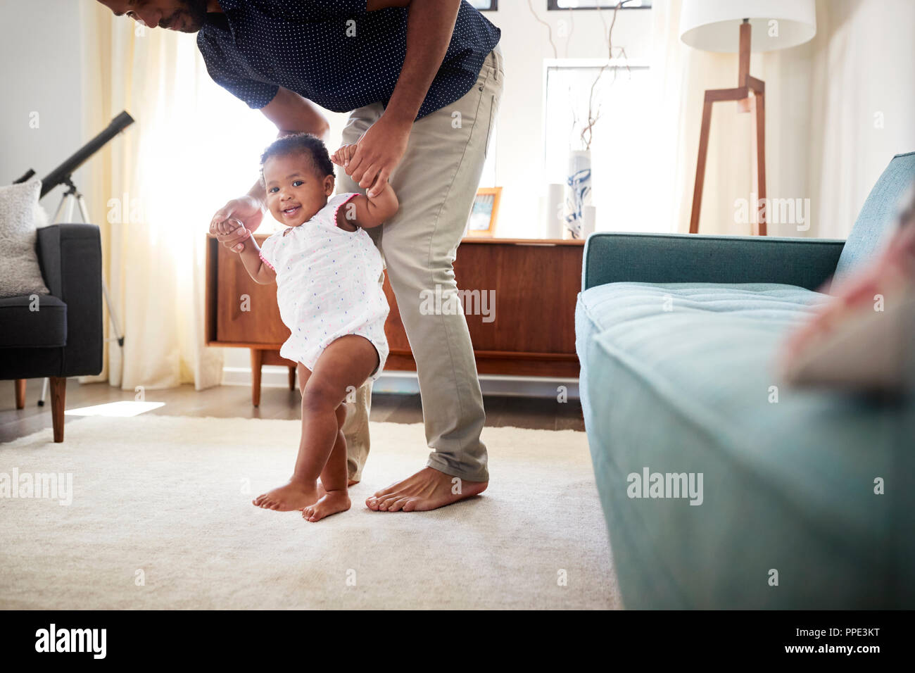 Father Encouraging Baby Daughter To Take First Steps At Home Stock ...