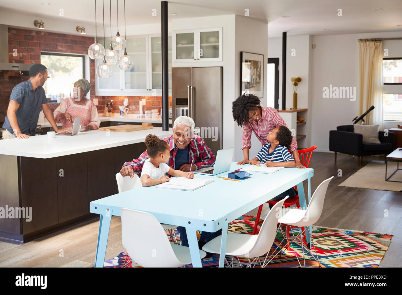 Children Doing Homework In Busy Multi Generation Family Home Stock ...