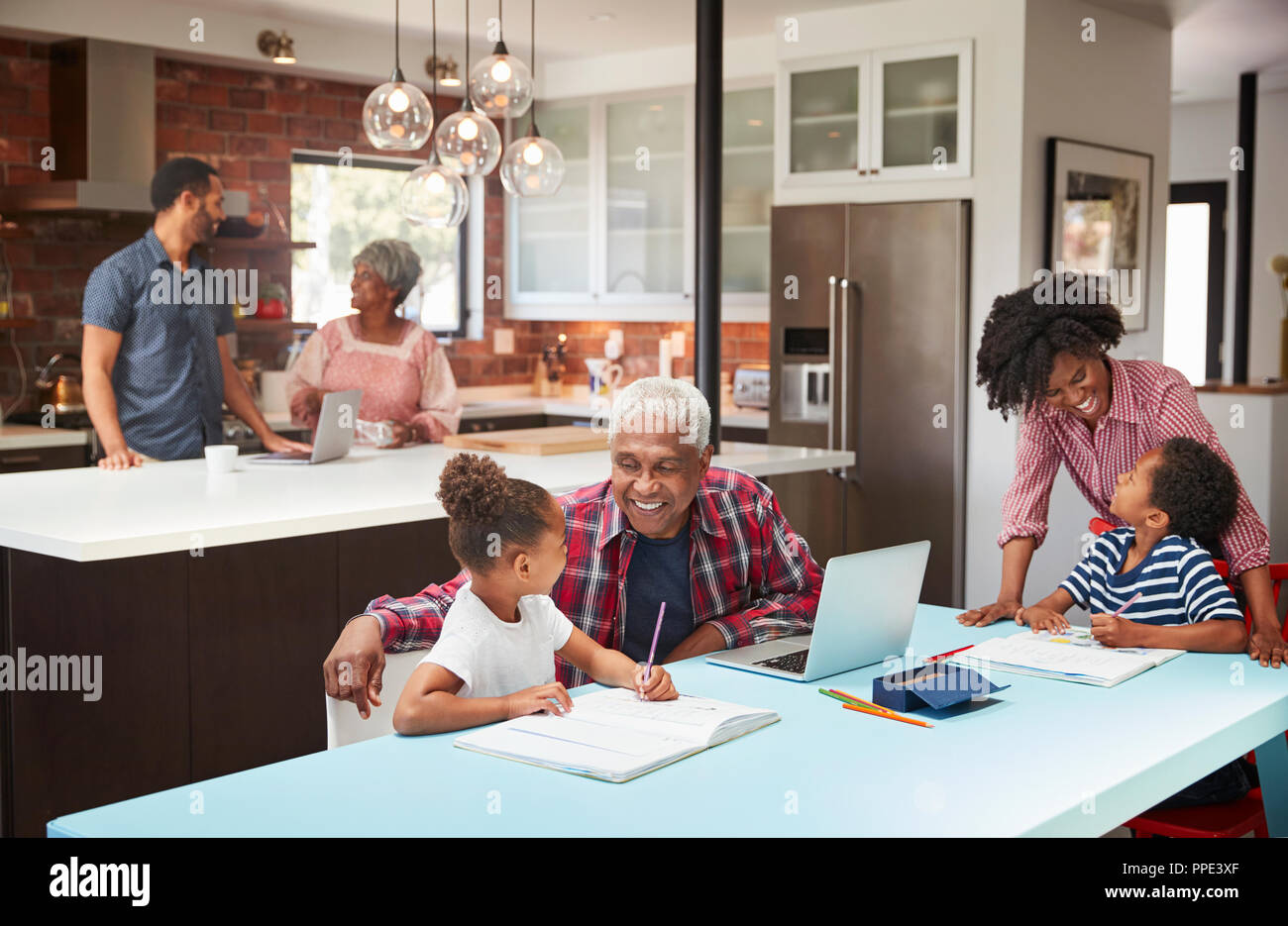 Children Doing Homework In Busy Multi Generation Family Home Stock ...