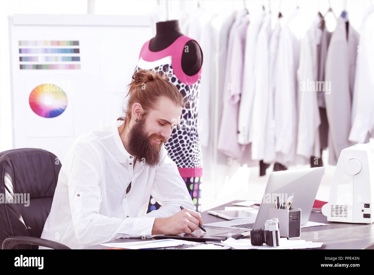 fashion designer uses a graphics tablet to create sketches of clothes ...