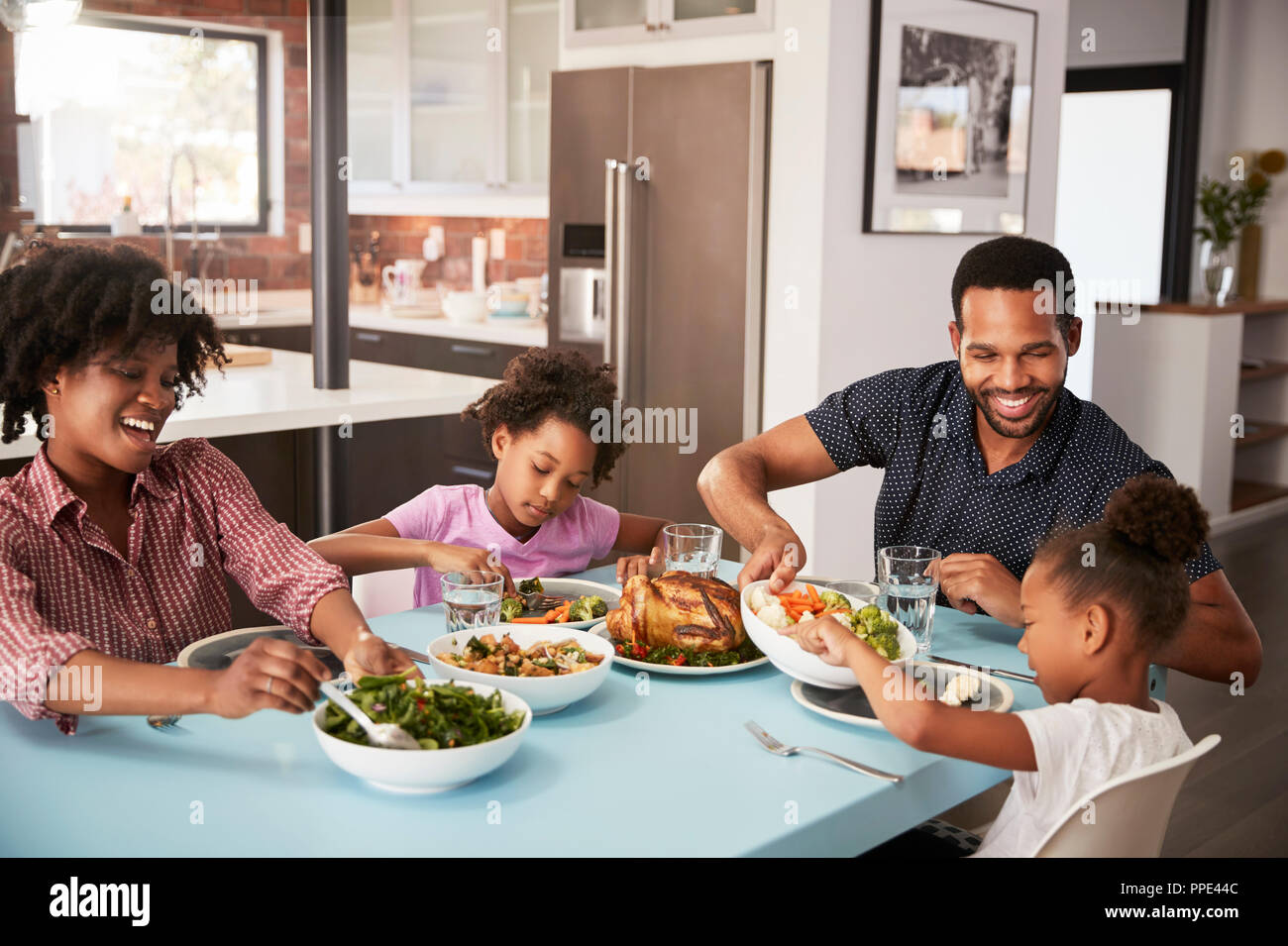 Family Enjoying Meal Around Table At Home Together Stock Photo - Alamy