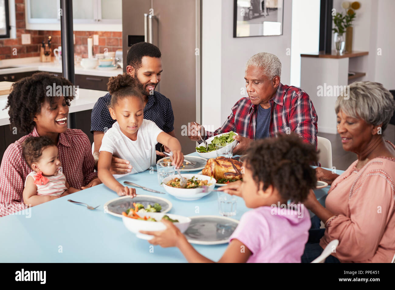 Multi Generation Family Enjoying Meal Around Table At Home Stock Photo ...
