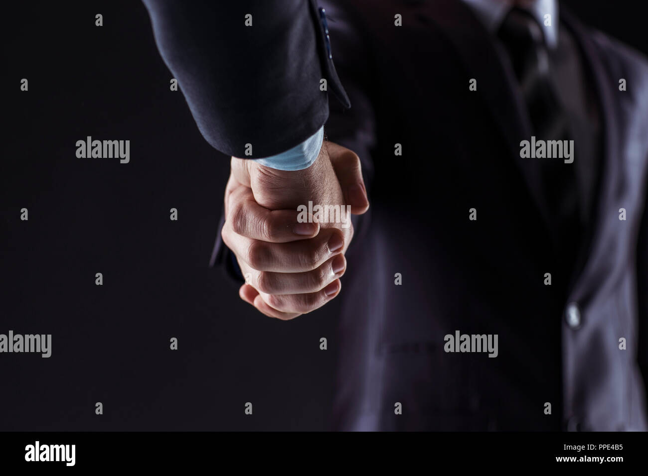 concept of a reliable partnership: a close-up of handshake of business ...