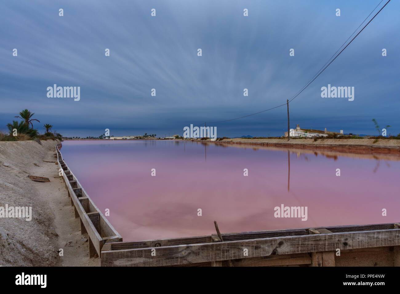 Pink salt pool at sunrise with dark clouds, ultra long exposure Stock ...