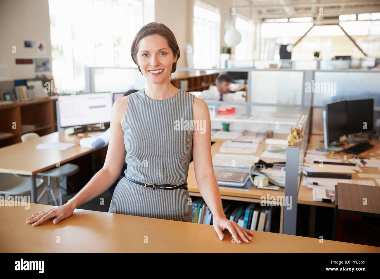 Young female architect in open plan office smiling to camera Stock ...