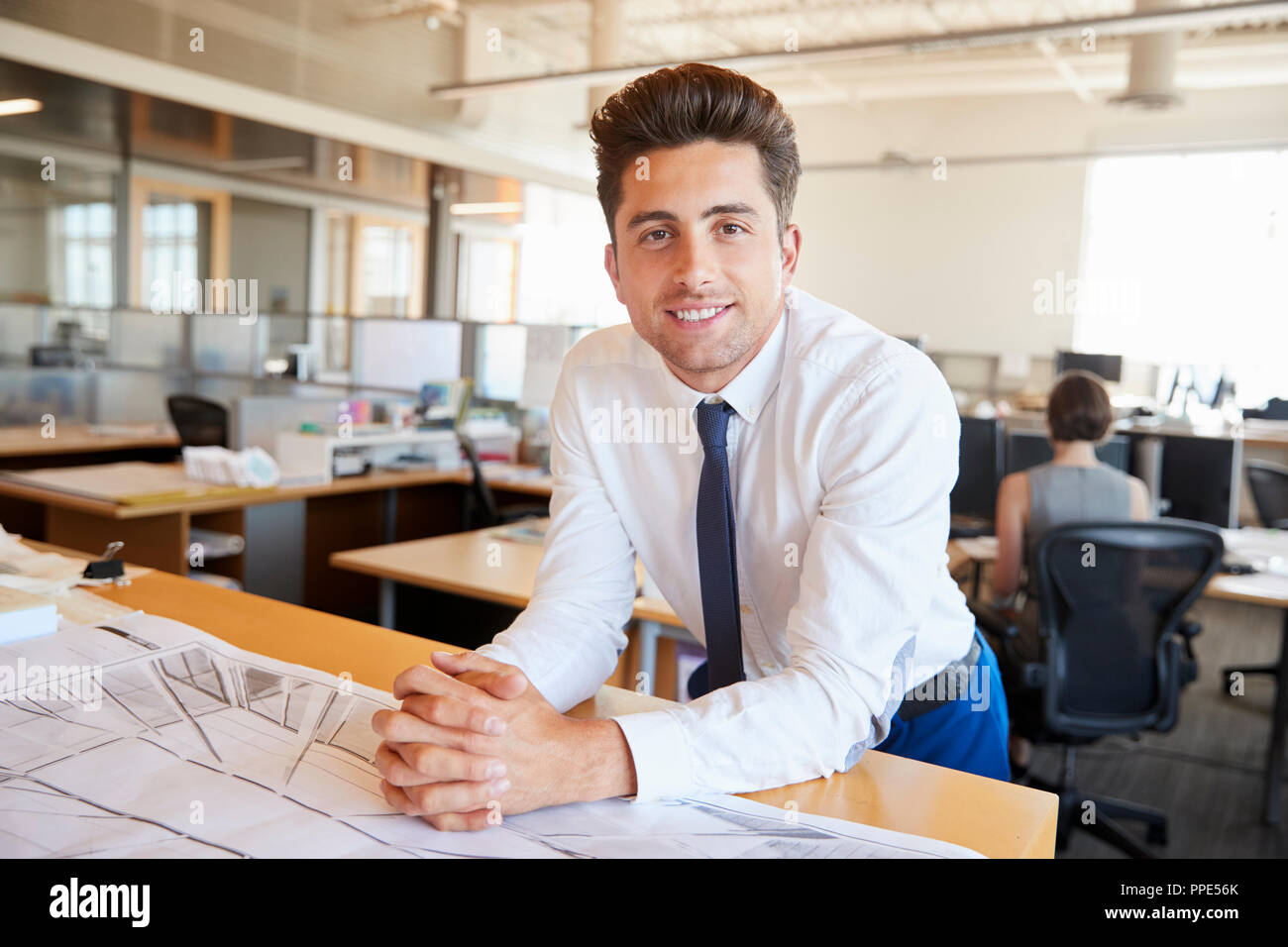 Young male architect leaning on desk smiling to camera Stock Photo - Alamy