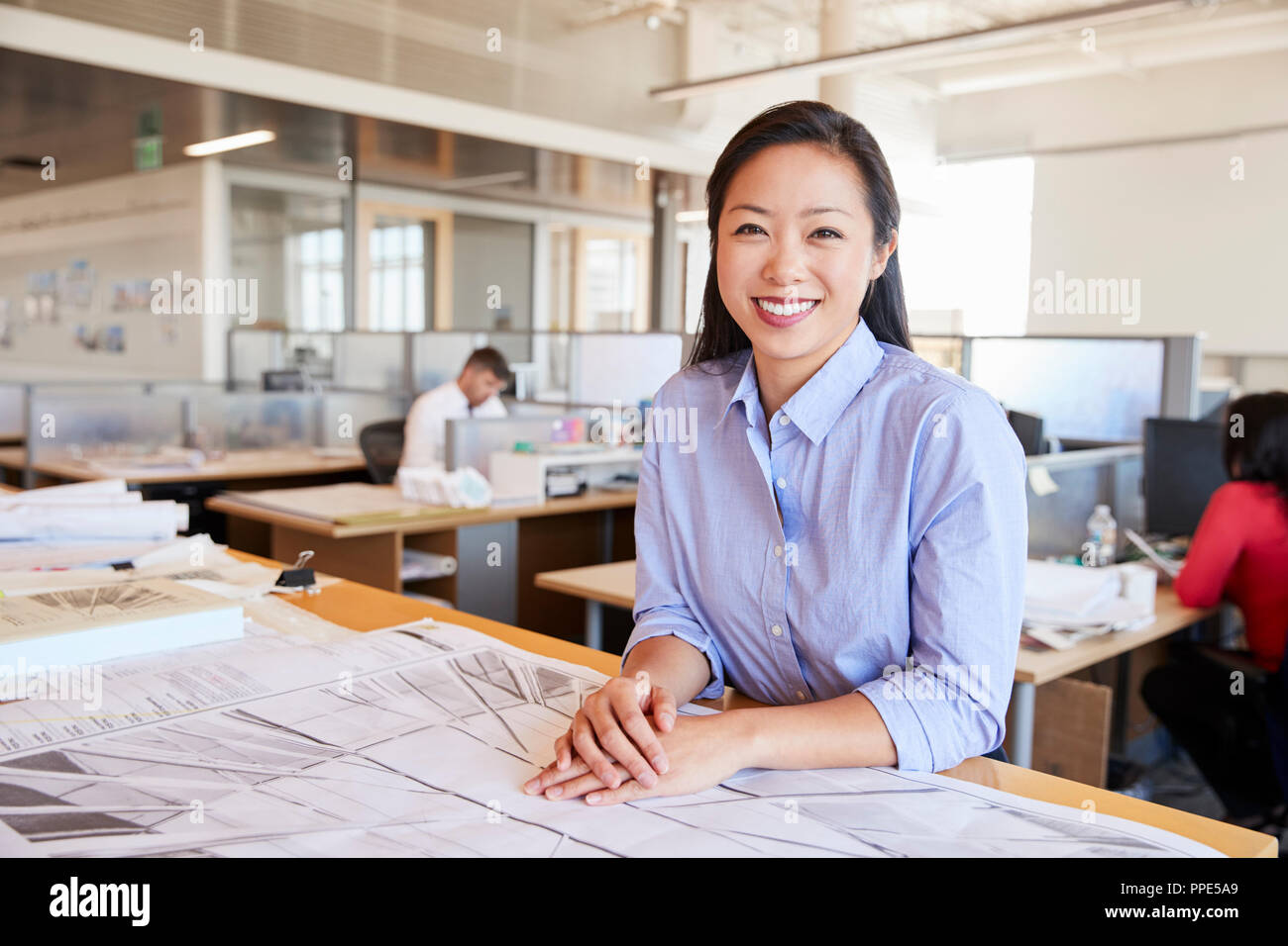 Female Asian architect smiling to camera in open plan office Stock ...